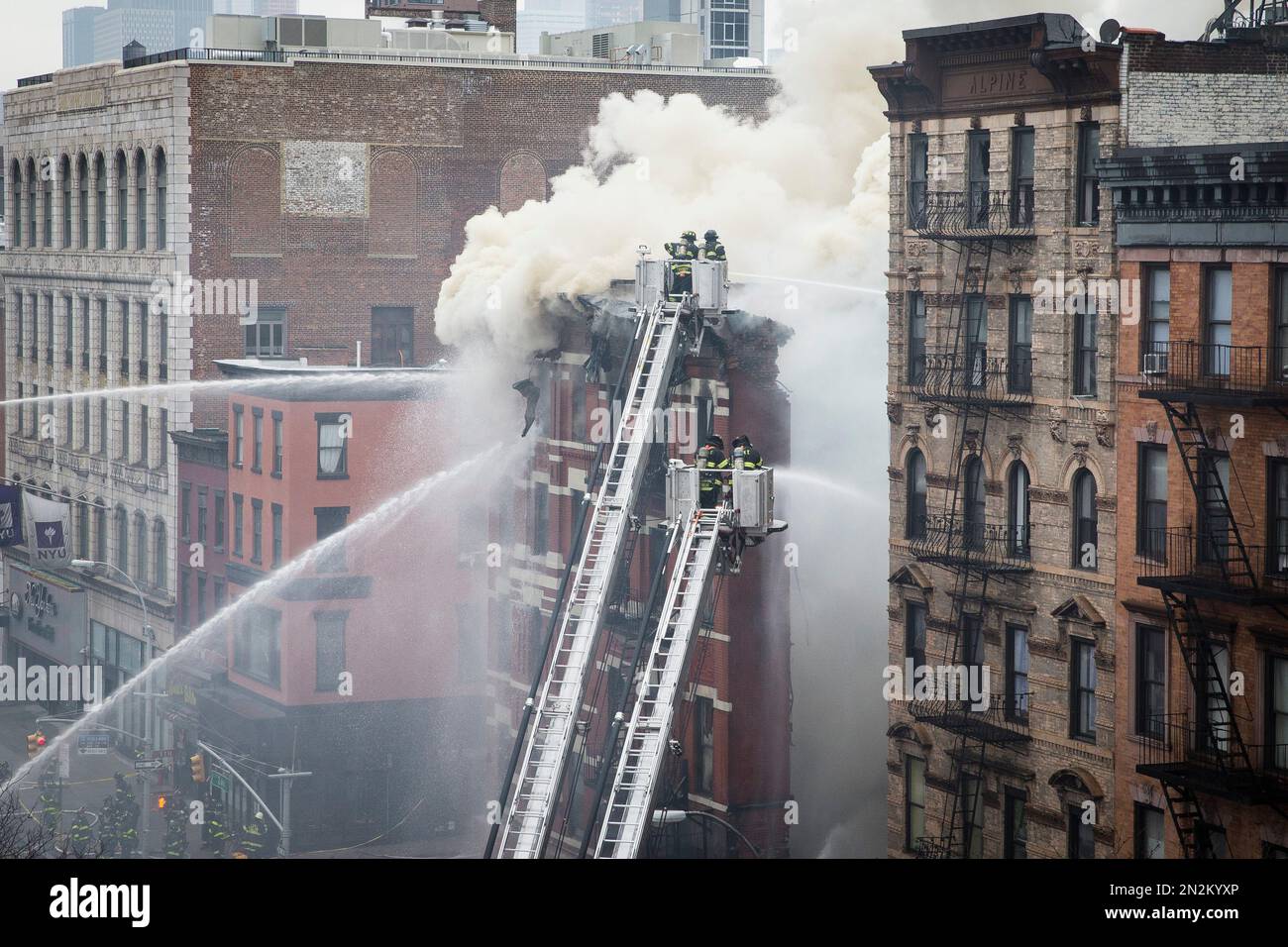 New York City firefighters work the scene of a large fire and a partial ...