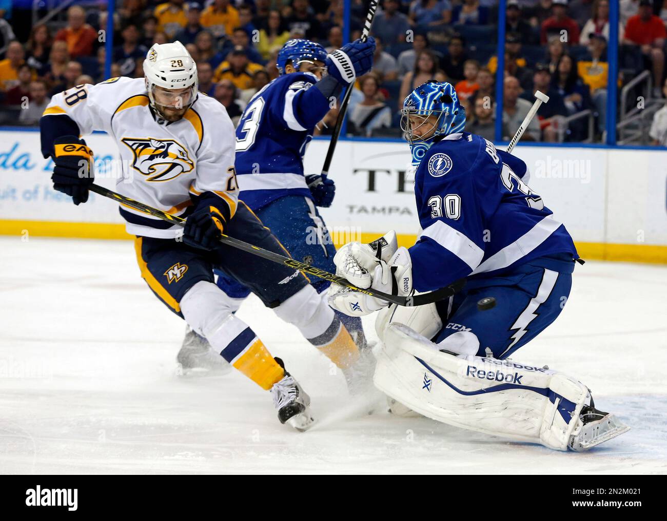 Nashville Predators' Paul Gaustad, left, tips a puck past Tampa Bay ...