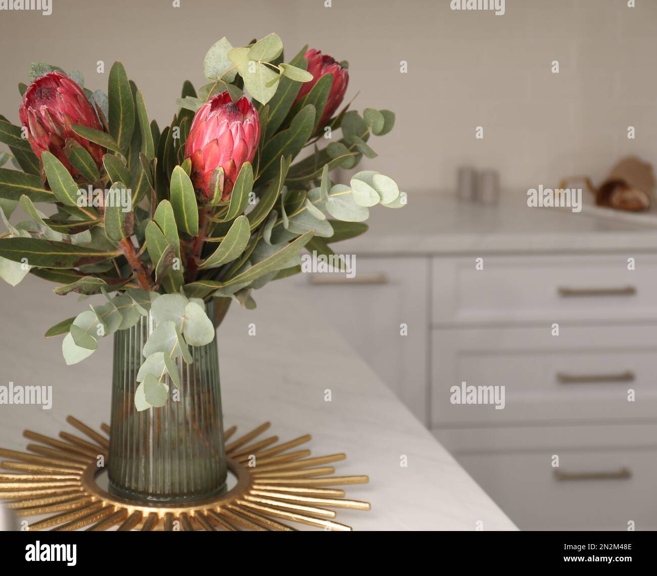 Bouquet with beautiful protea flowers on countertop in kitchen, space ...