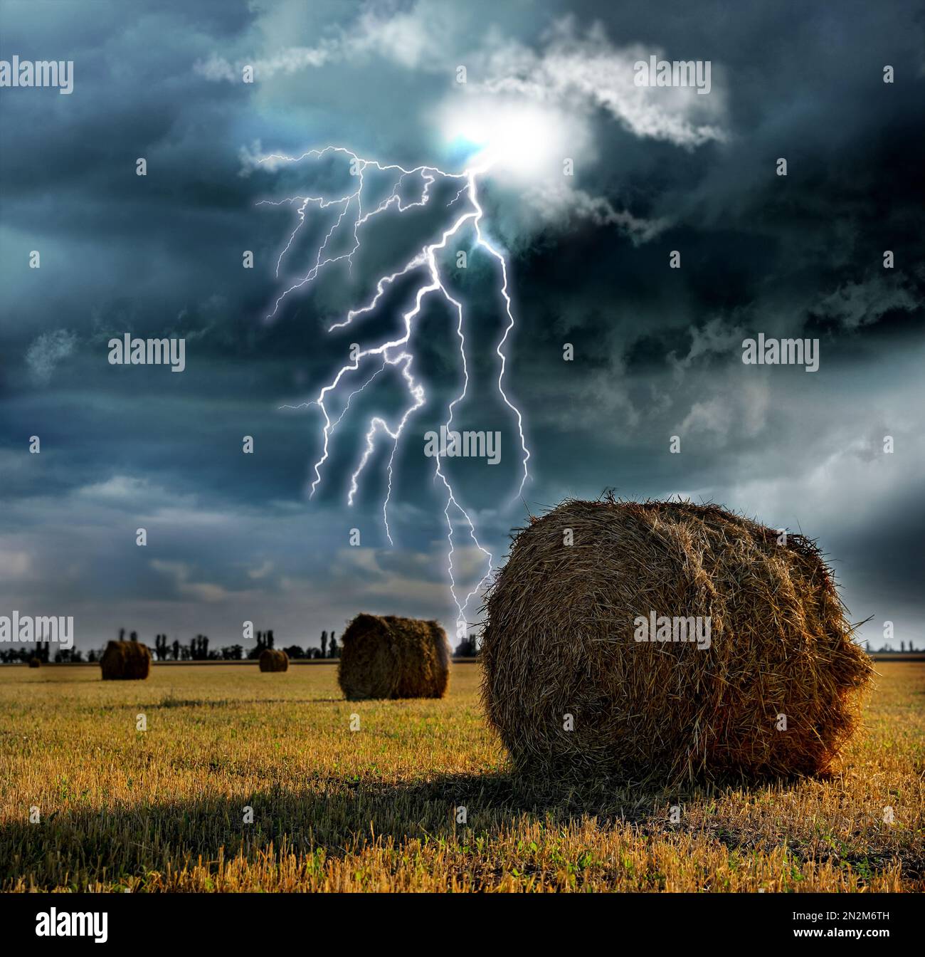 Picturesque lightning storm over field with rolled hay bales Stock ...
