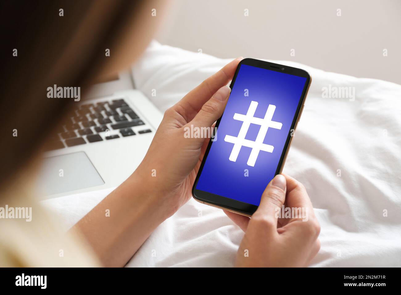 Woman using modern smartphone with hashtag symbol on screen, closeup ...