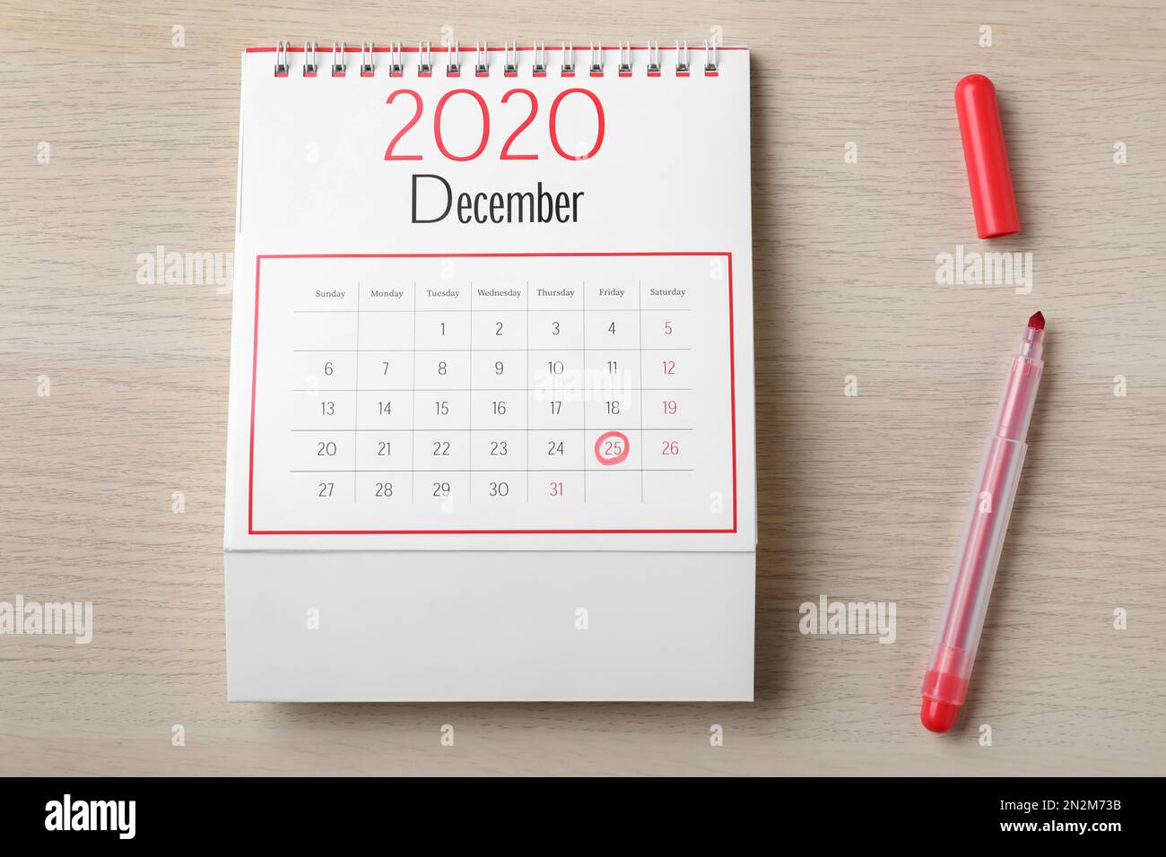 Calendar with marked date and red marker on wooden table, flat lay ...