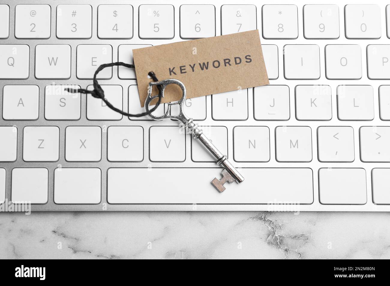 Keyboard, vintage key and tag with word KEYWORDS on white marble table ...