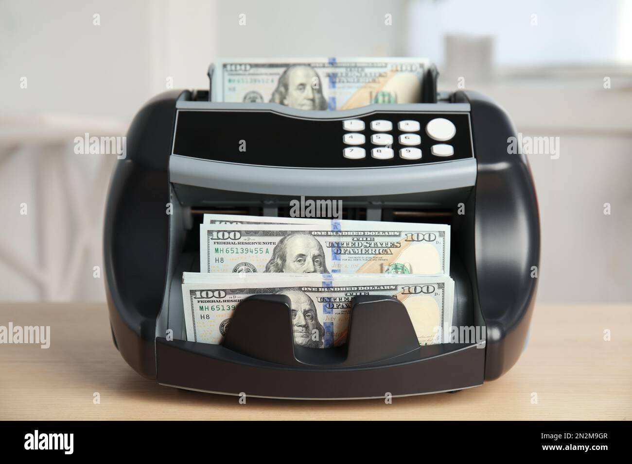 Modern electronic bill counter with money on table indoors Stock Photo ...
