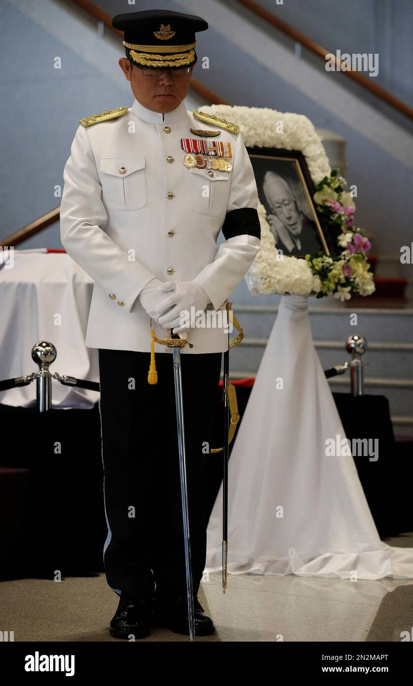 A vigil guard stands with his head bowed and ceremonial sword inverted ...
