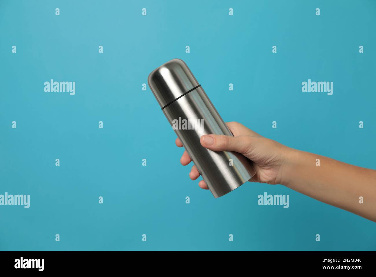 Woman holding modern thermos on light blue background, closeup Stock ...