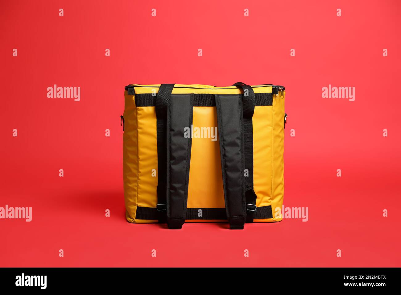 Modern yellow thermo bag on red background Stock Photo - Alamy