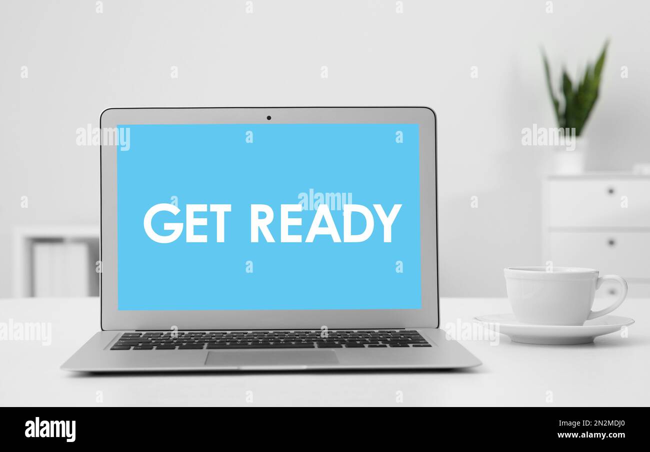 Modern laptop with phrase Get Ready on screen in office Stock Photo - Alamy