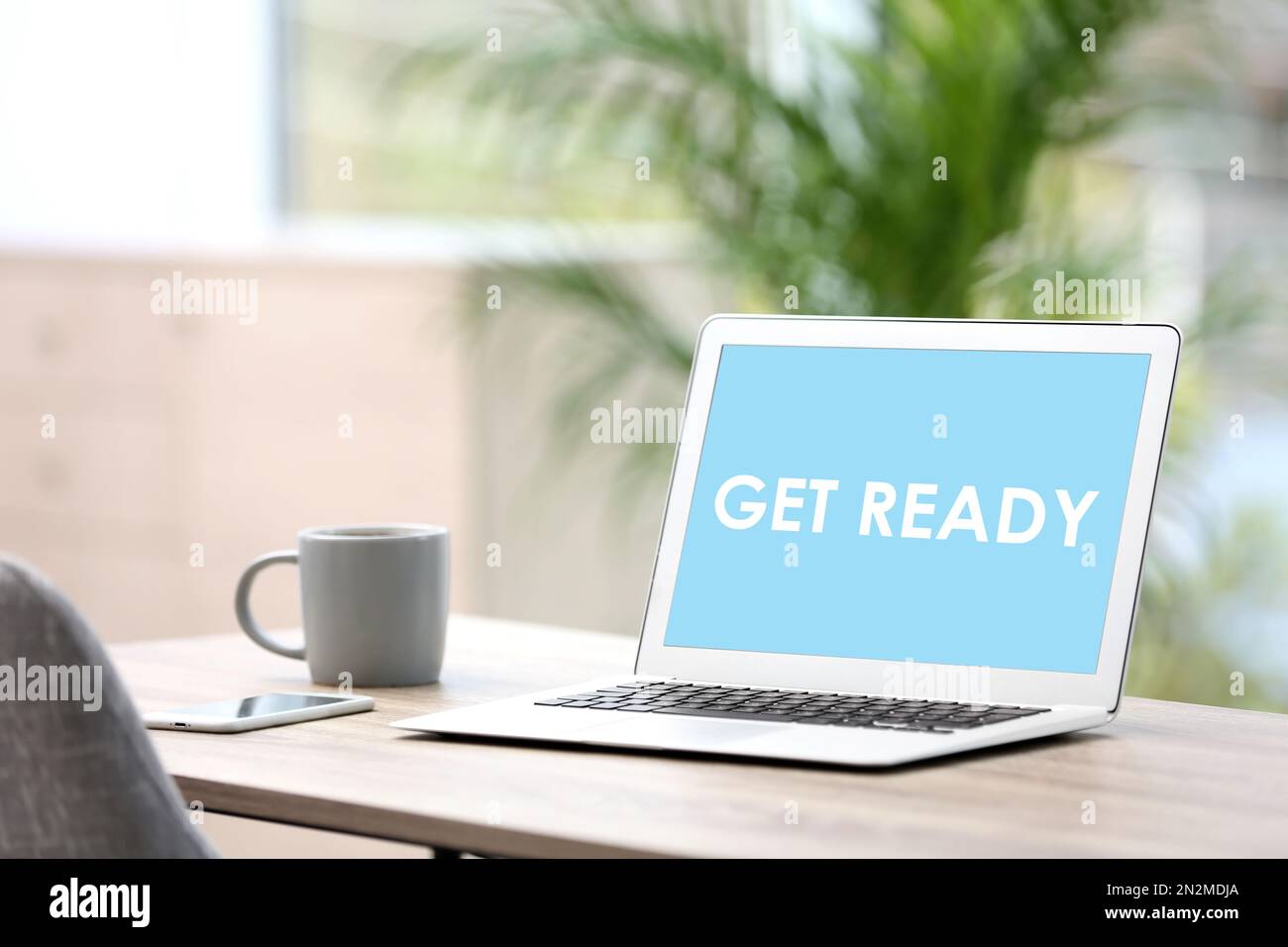 Modern laptop with phrase Get Ready on screen in office Stock Photo - Alamy
