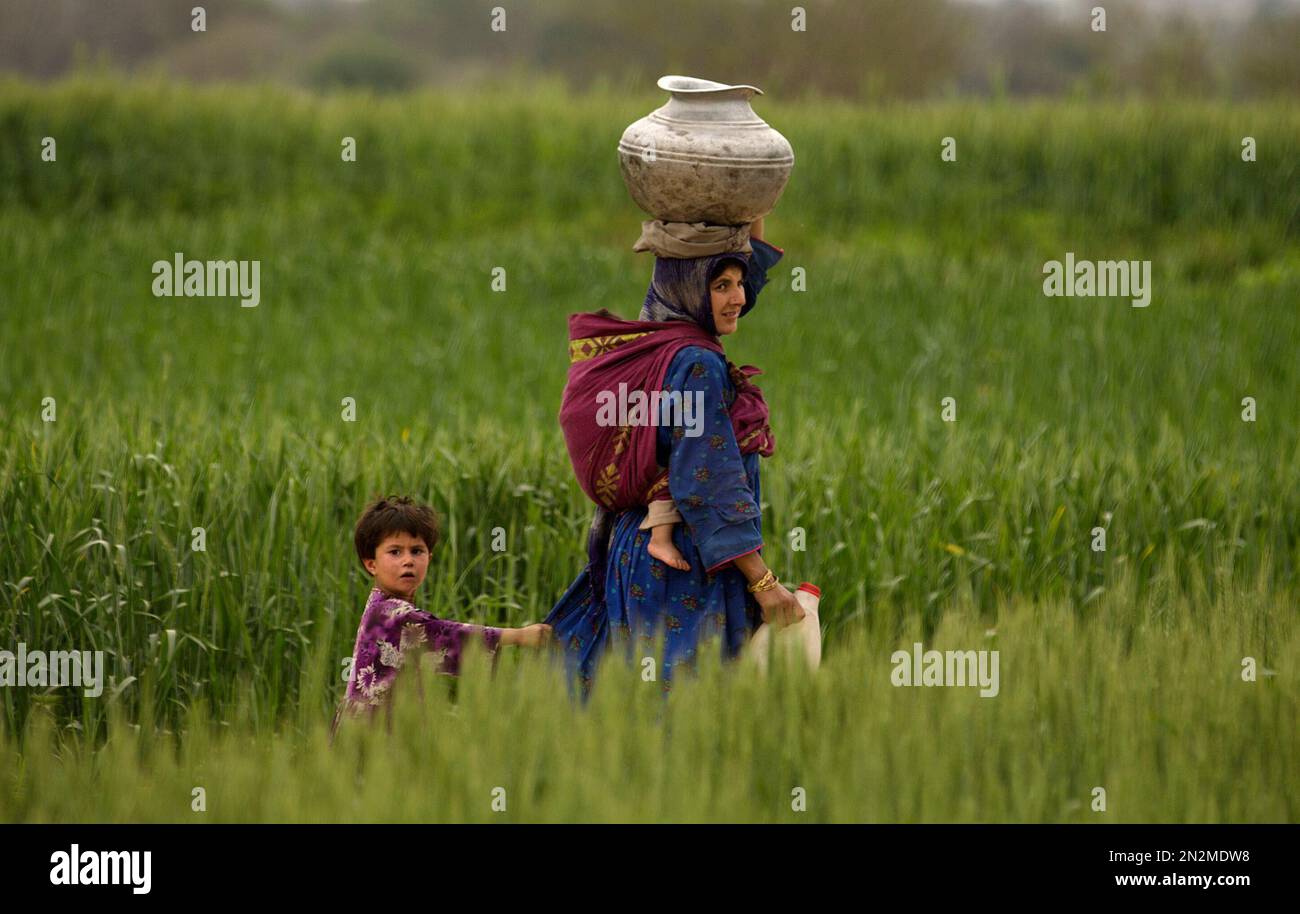 A Pakistani woman fetches clean water to her home in Islamabad's slums ...