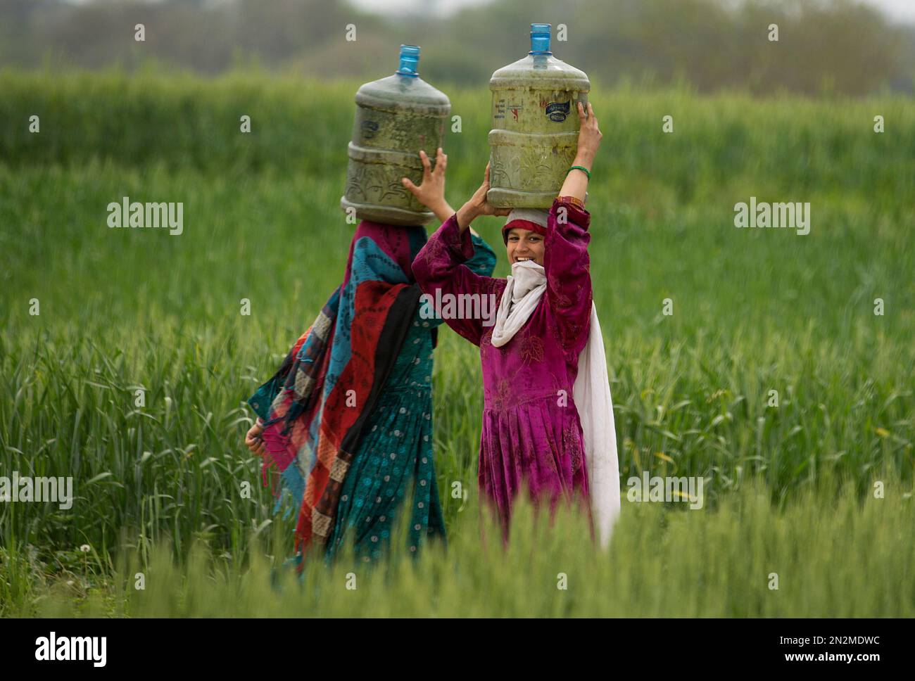 Pakistani girls carry clean water to their home in Islamabad's slums in ...