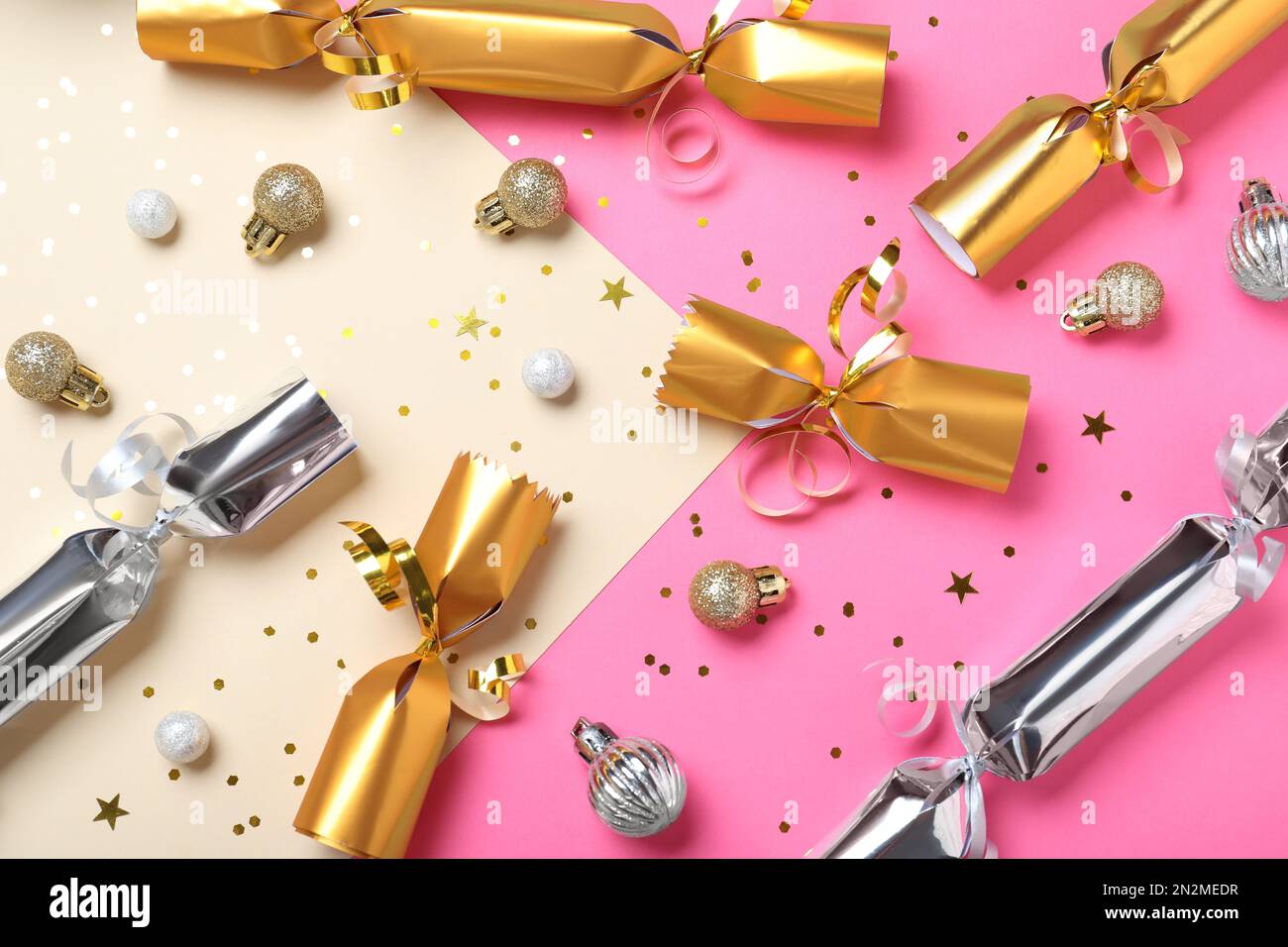 Christmas crackers with decorations and shiny confetti on color ...