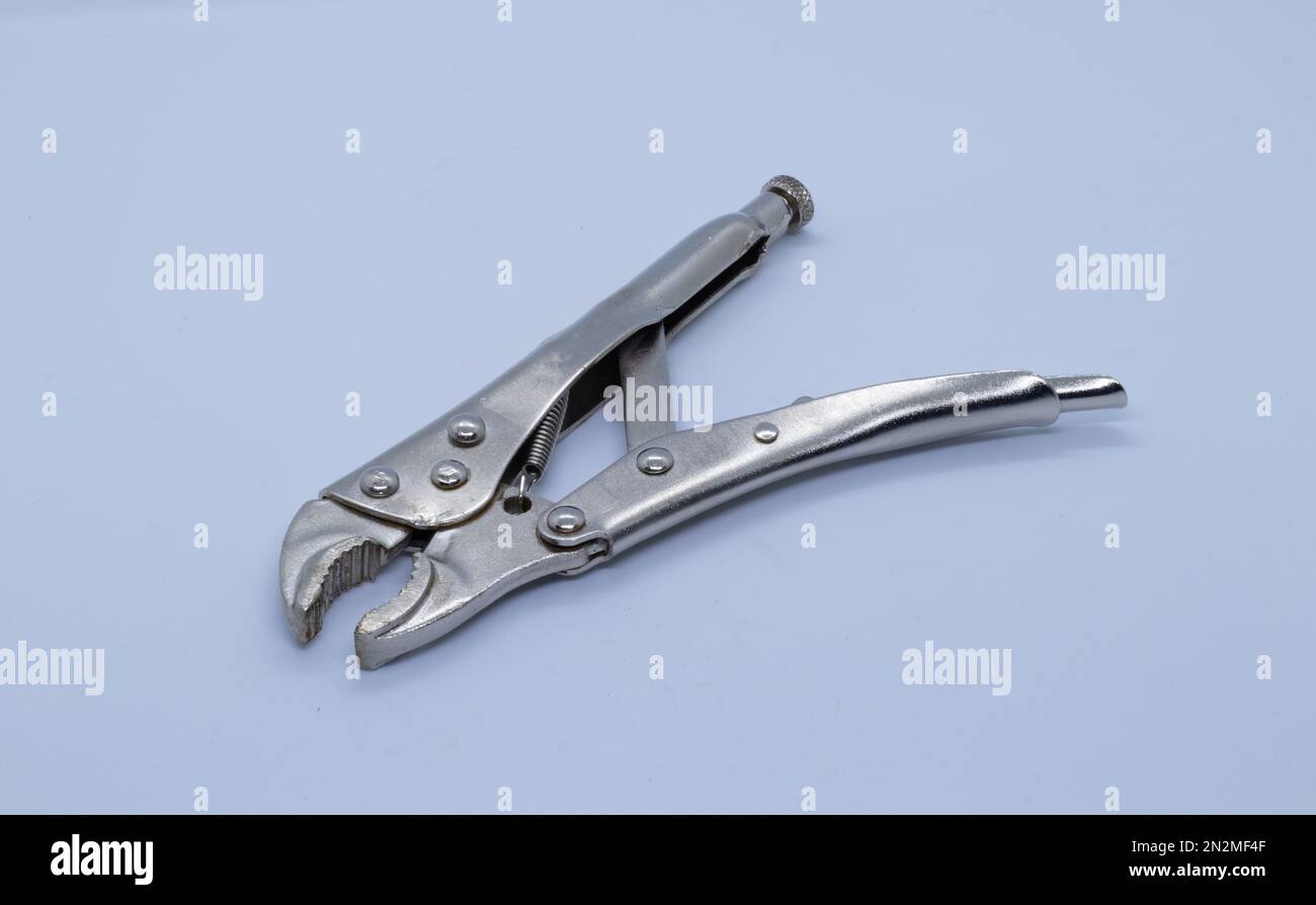 A Metallic tweezer for work on light blue background Stock Photo - Alamy
