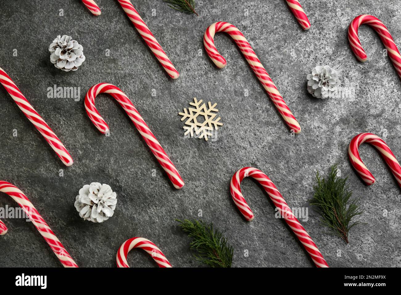 Flat lay composition with candy canes and Christmas decor on grey table ...
