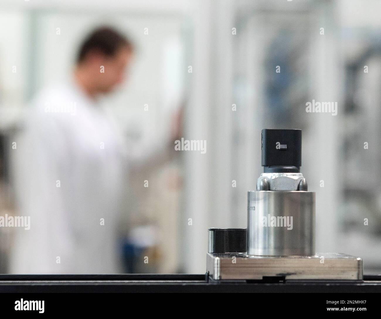 A employee stands at the assembly line behind a climate pressure sensor ...