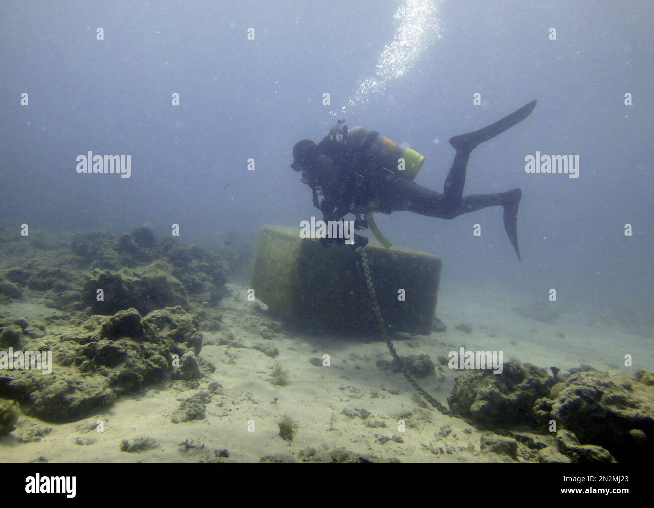 A member of a local citizens group, Osamu Makishi, inspects the damage ...