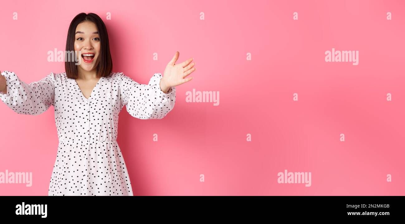 Happy asian girl stretching hands to camera, reaching for hug, smiling ...