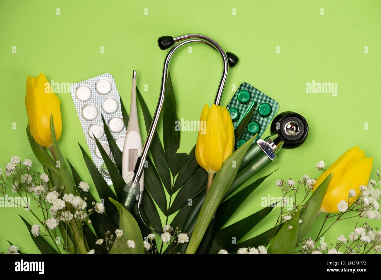 Bouquet of flowers and stethoscope on a green background, happy doctors ...