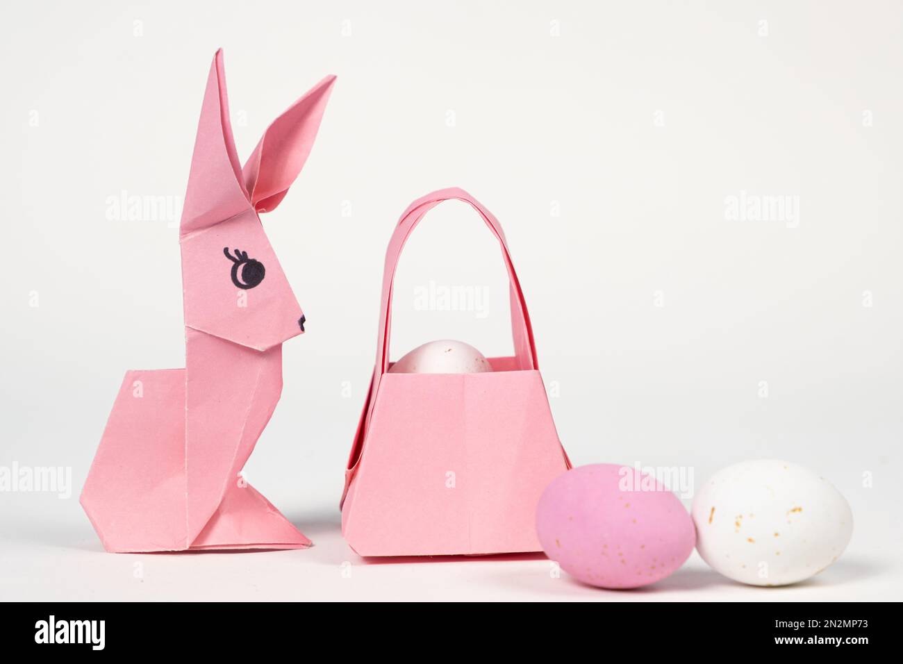 Easter origami bunny and a basket of eggs on a white background. Paper ...