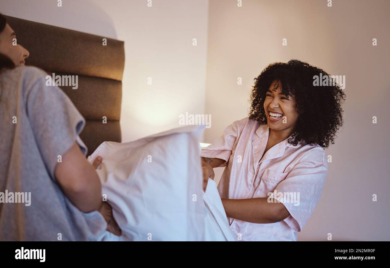 Women, laughing or pillow fight in house, home or hotel bedroom in fun ...