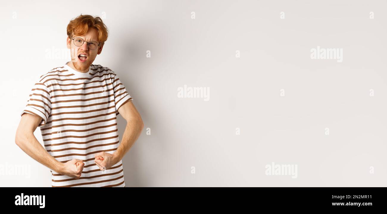 Image of confident and strong redhead man flexing biceps, showing ...
