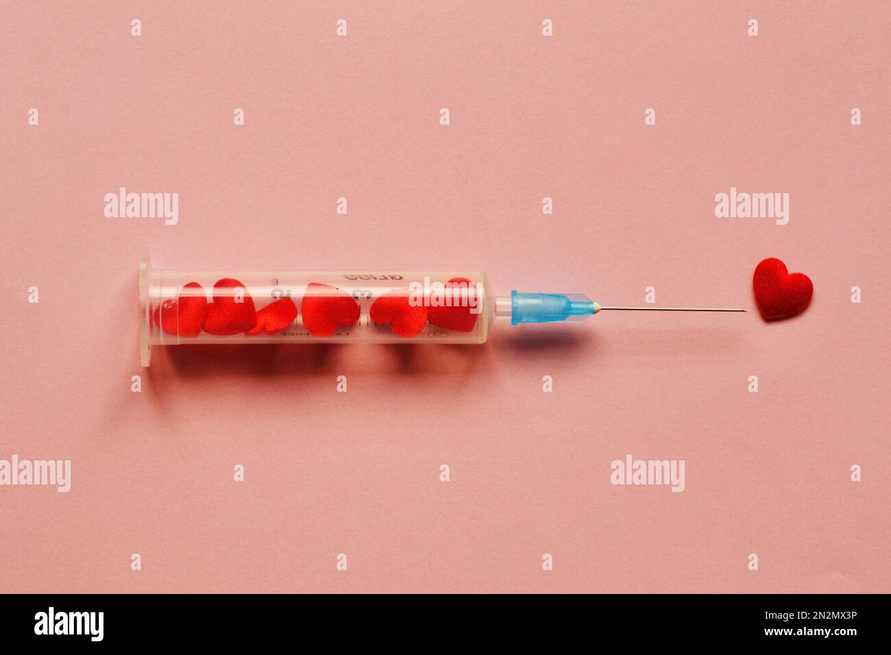 Syringe full of hearts on pink background - Love concept Stock Photo ...