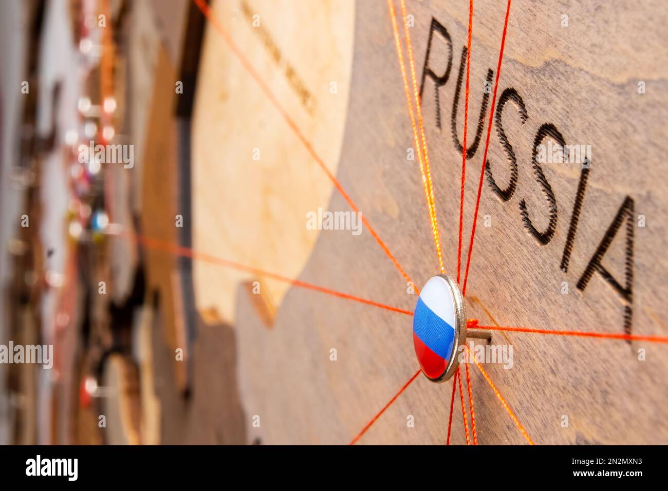Russia flag on the pushpin and red threads on the wooden map. Travel or ...