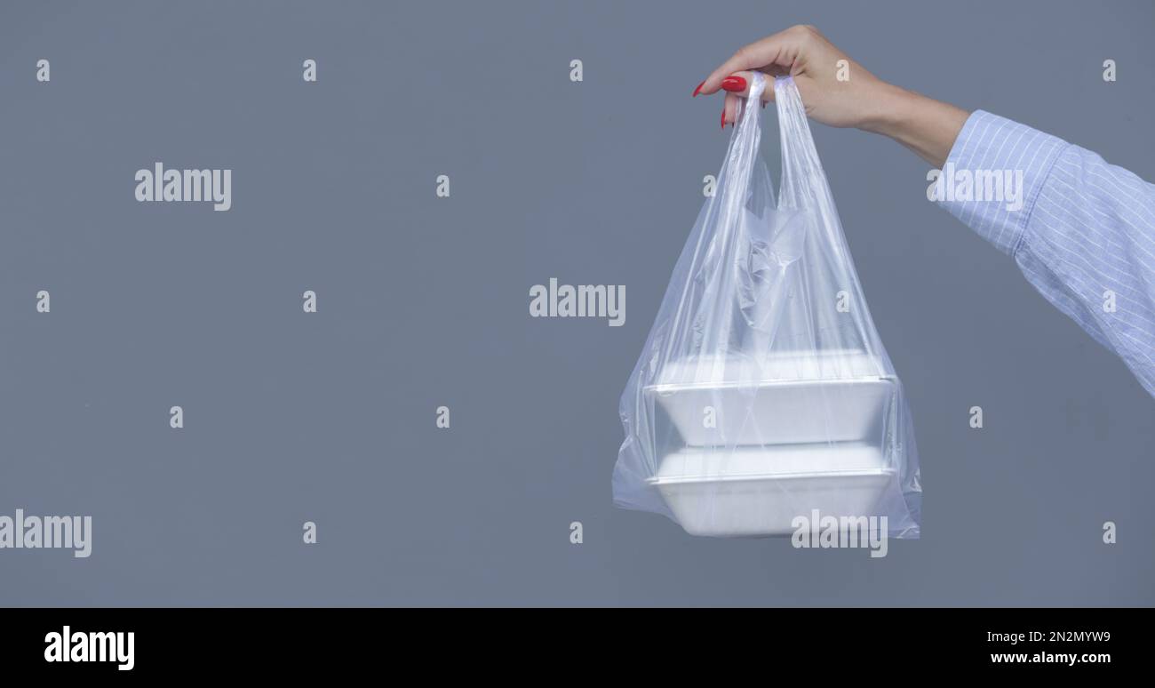 Woman's hands holding PVC plastic bag with takeaway foam lunch boxes ...