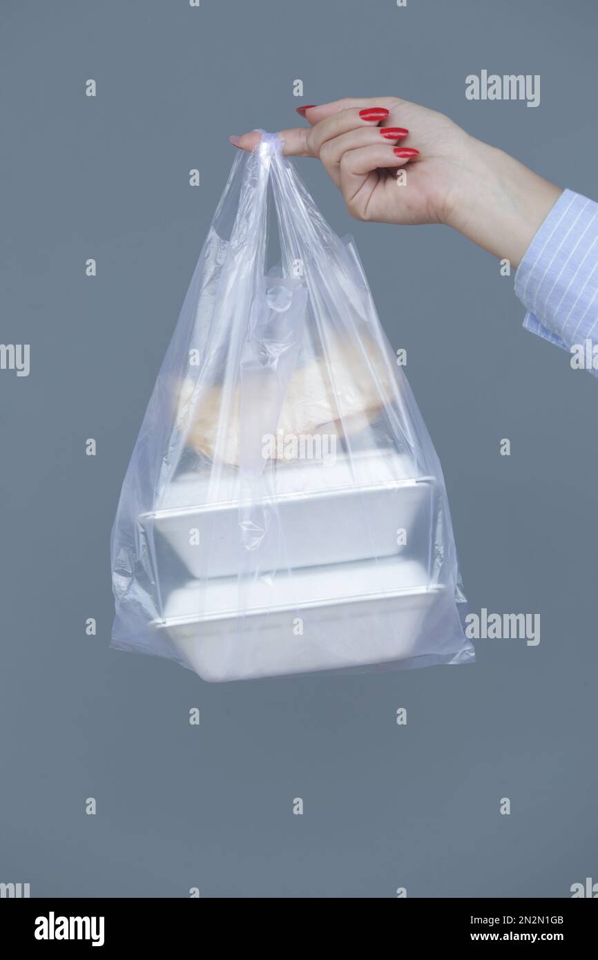 Woman's hands holding PVC plastic bag with takeaway foam lunch boxes ...