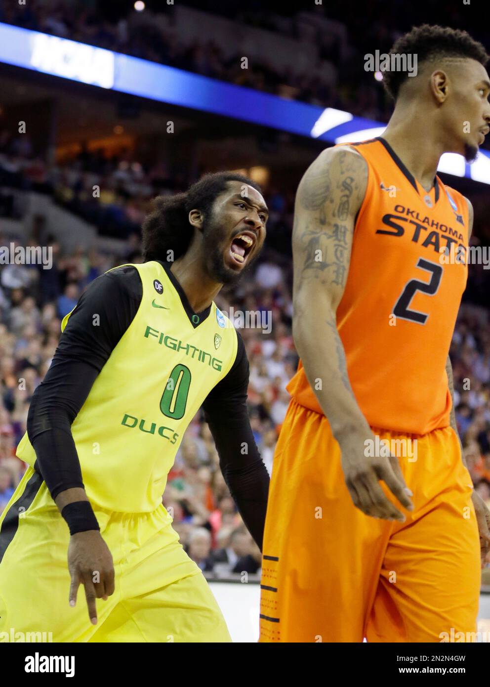 Oregon forward Dwayne Benjamin, left, reacts in front of Oklahoma State ...