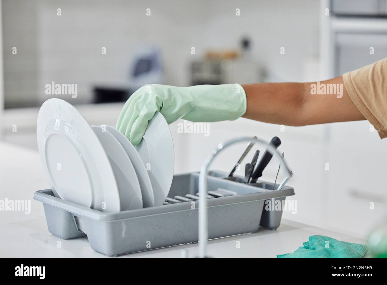 Woman hand, plate dishes and sink in kitchen for washing, cleaning and ...