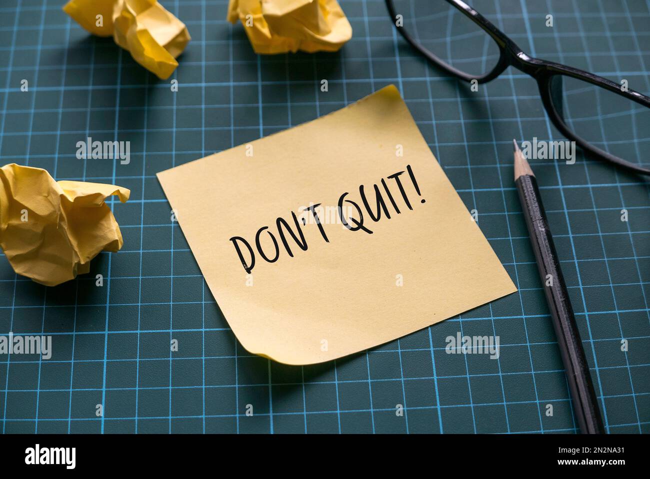 A paper trash, glasses, pencil and a yellow paper note written with Don ...