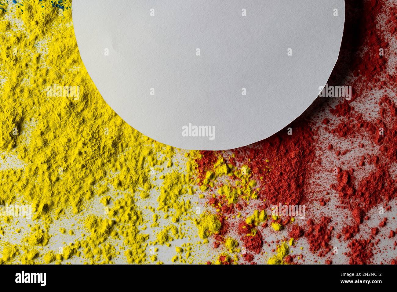 Close up of red and yellow coloured powder and white circle with copy ...