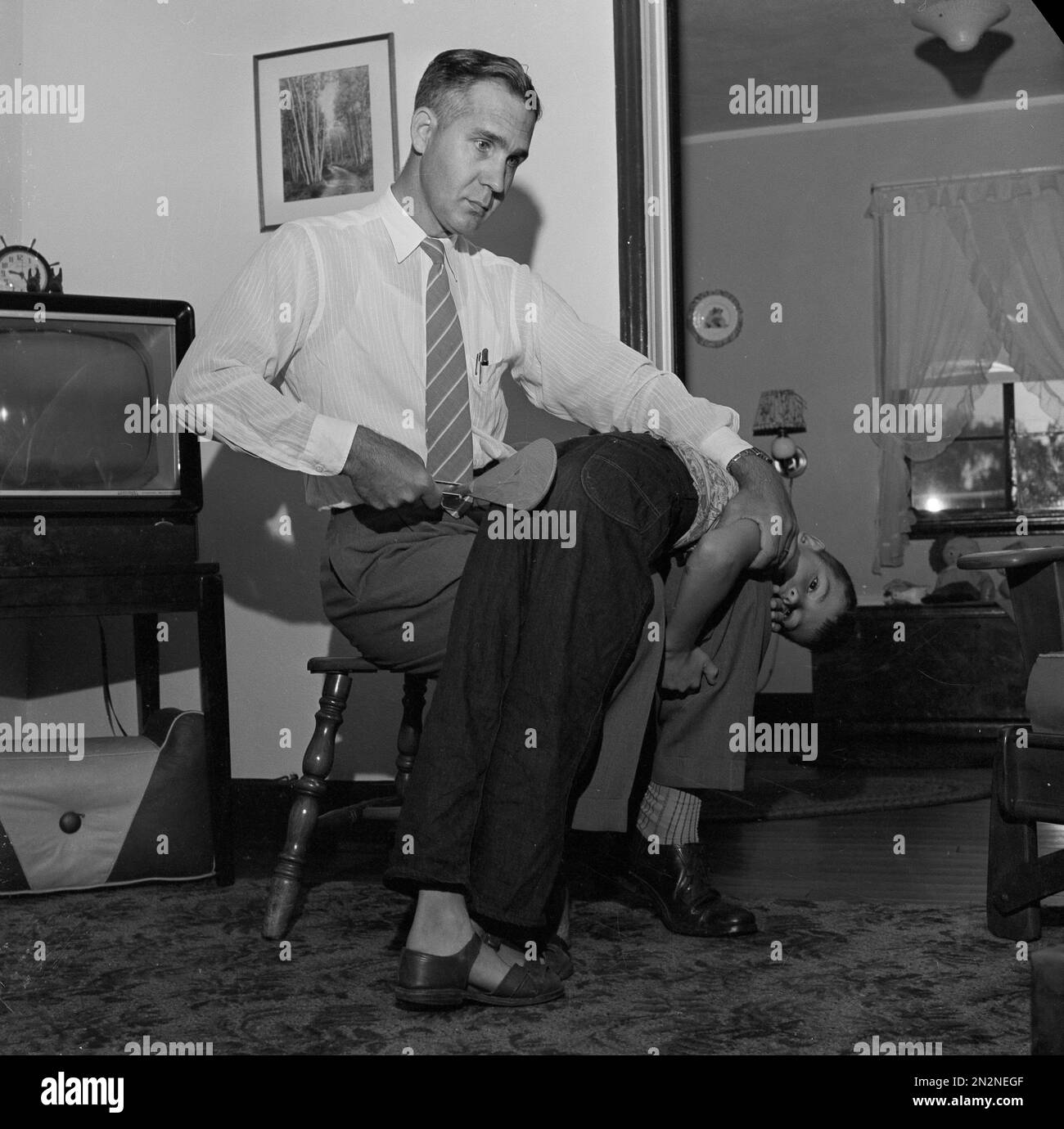 George F. Jorgenson demonstrates a safe spanking device he invented on ...