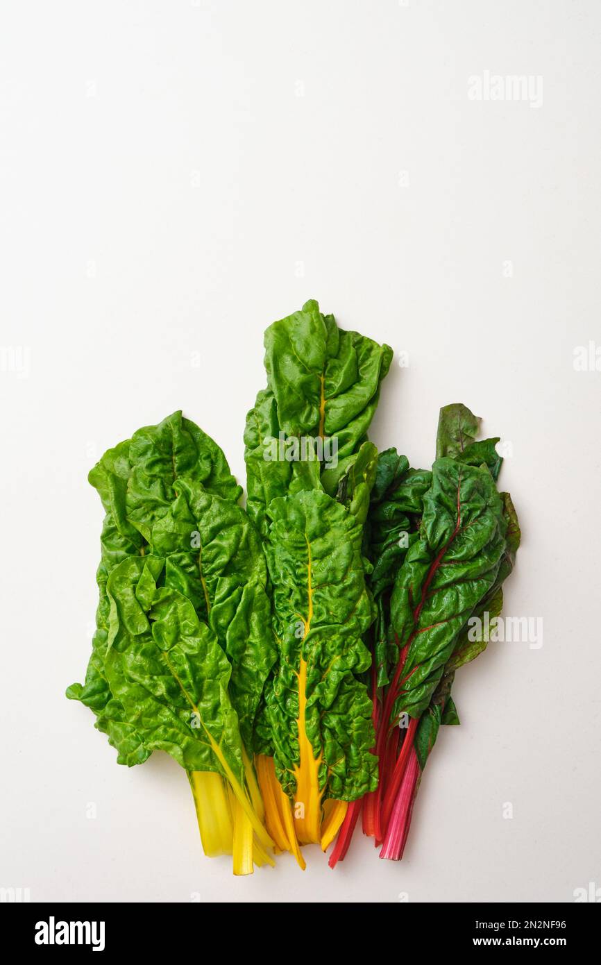 Bunch of rainbow swiss chard leaves on beige stone table Stock Photo ...