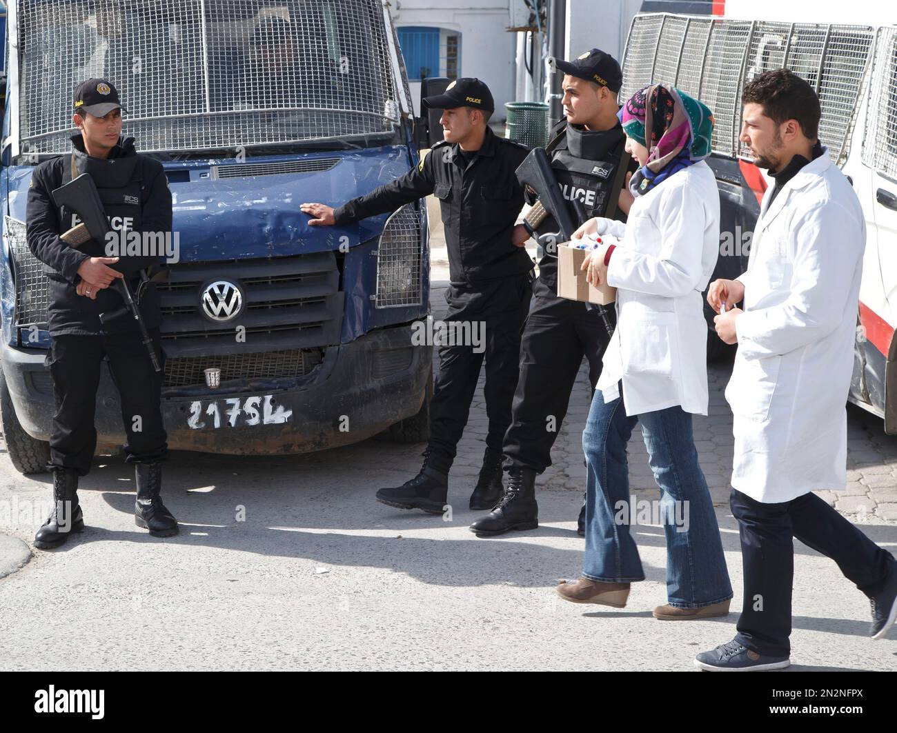 Tunisian police officers, stand guard at the Charles Nicolle hospital ...