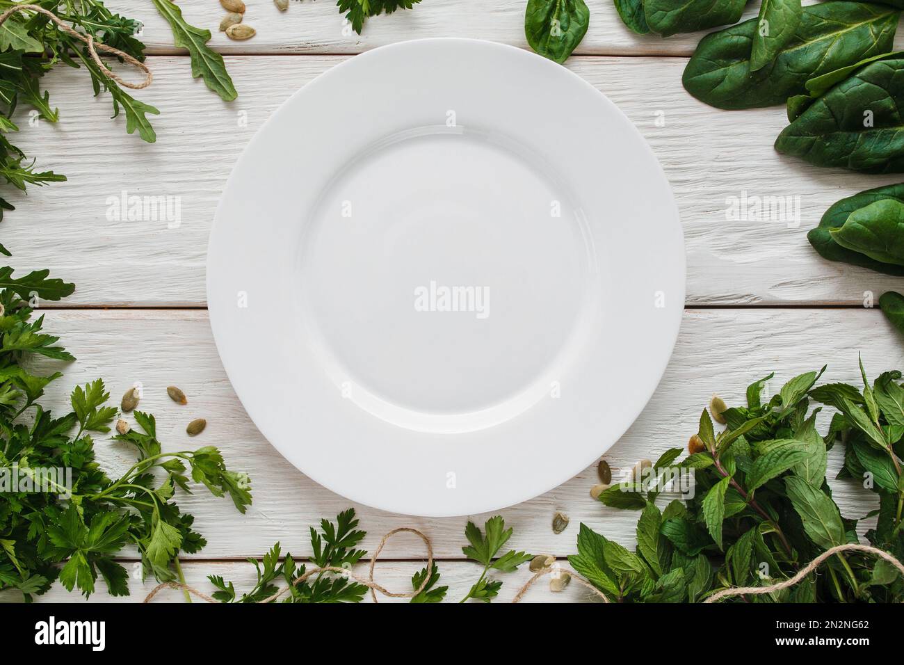 Empty white plate in seasoning frame void flat lay Stock Photo - Alamy