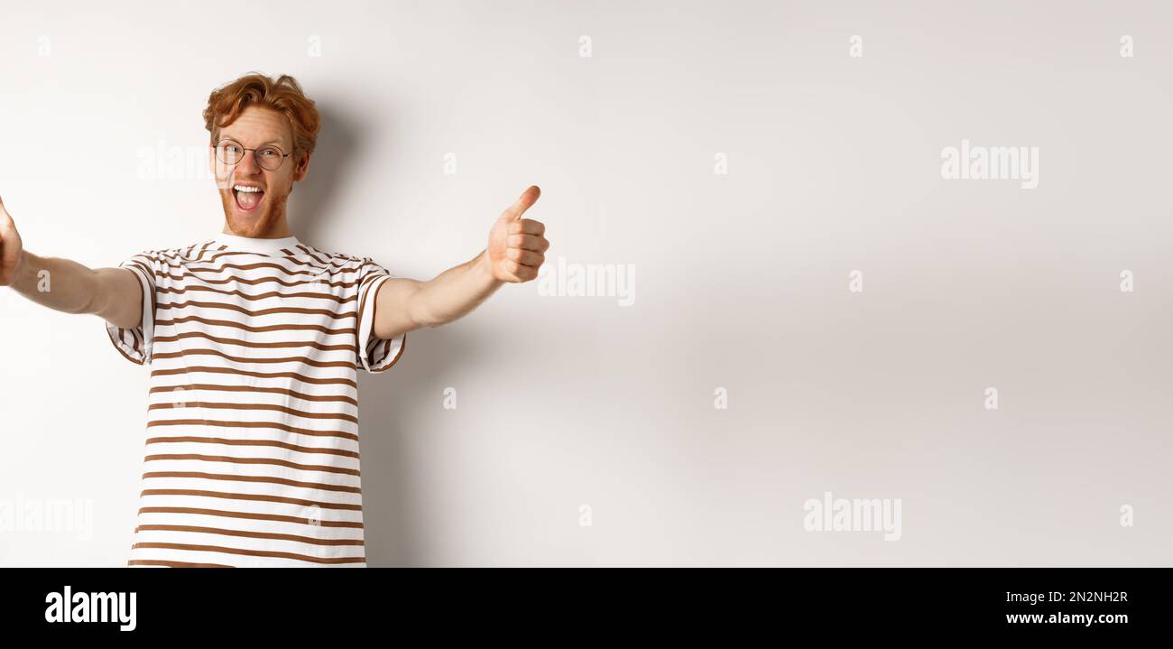 Happy redhead man scream yes and showing thumbs-up, approve and praise ...