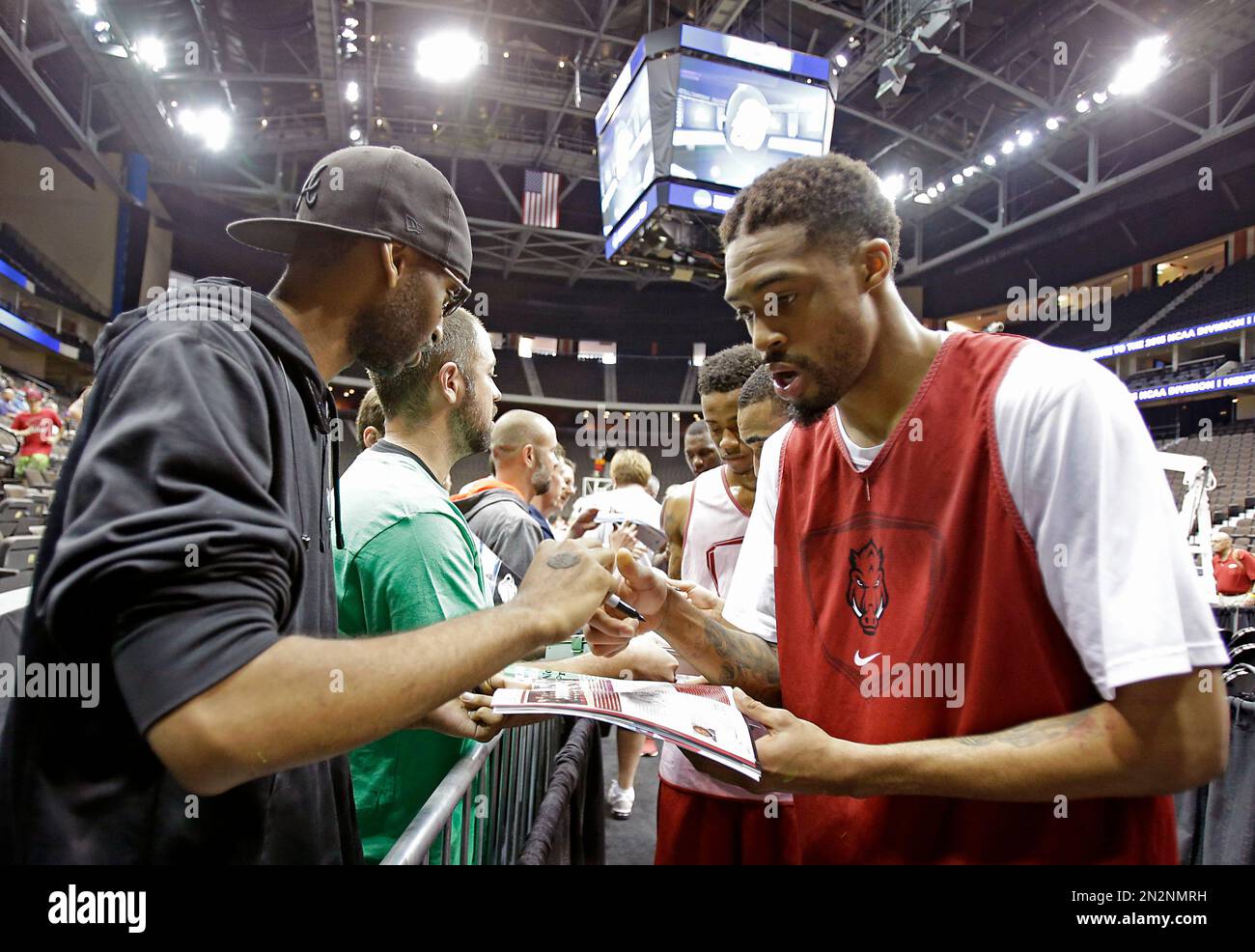 Arkansas guard Rashad Madden, right, signs autographs for fans after a ...