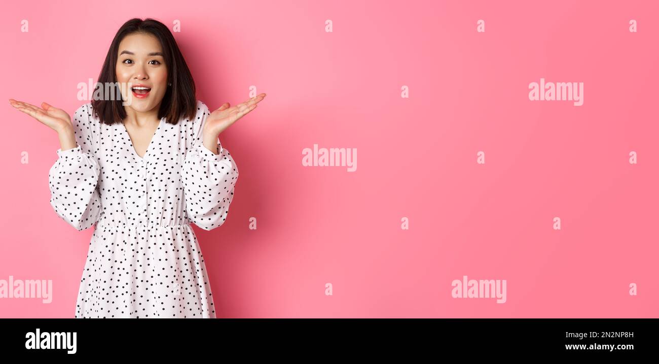 Image of surprised korean girl in dress, female model staring at camera ...