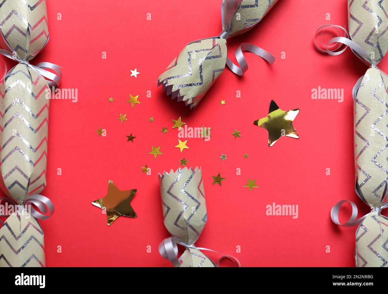 Open and closed Christmas crackers with shiny confetti on red ...