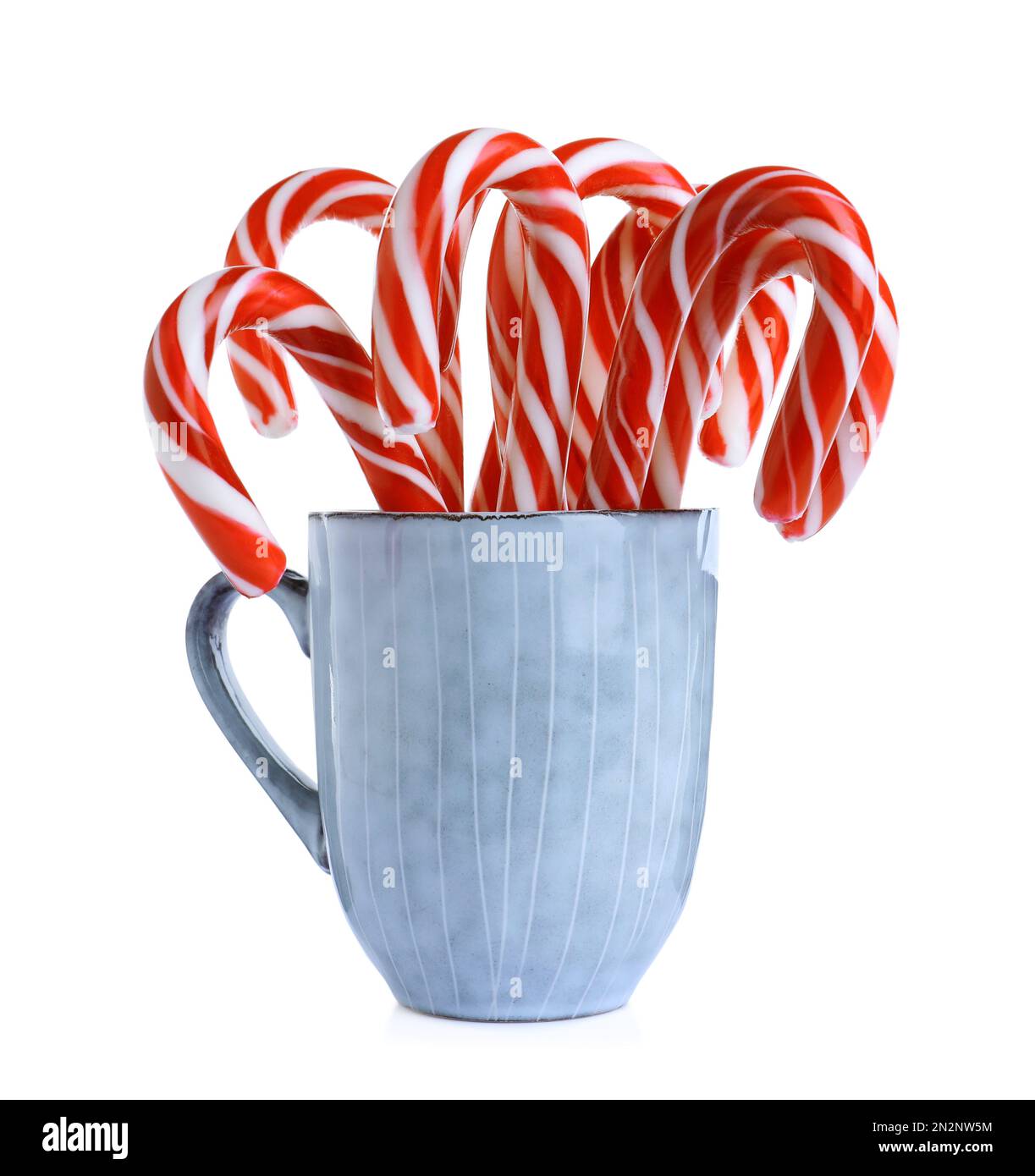 Grey cup with sweet Christmas candy canes isolated on white Stock Photo ...