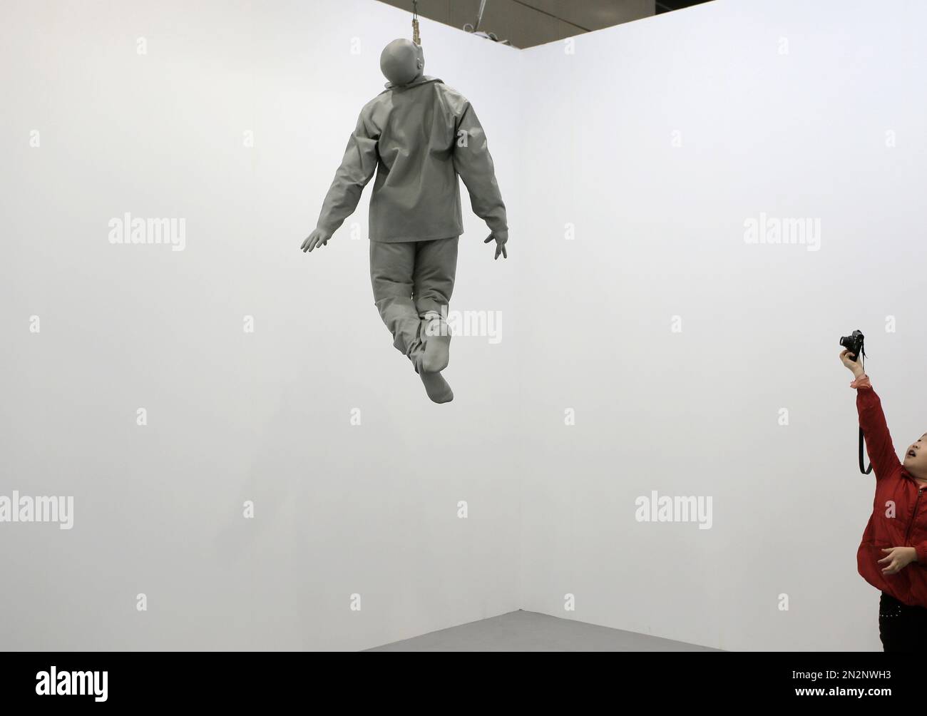 In this March 15, 2015, photo, a girl photographs "Hanging Figure" by ...