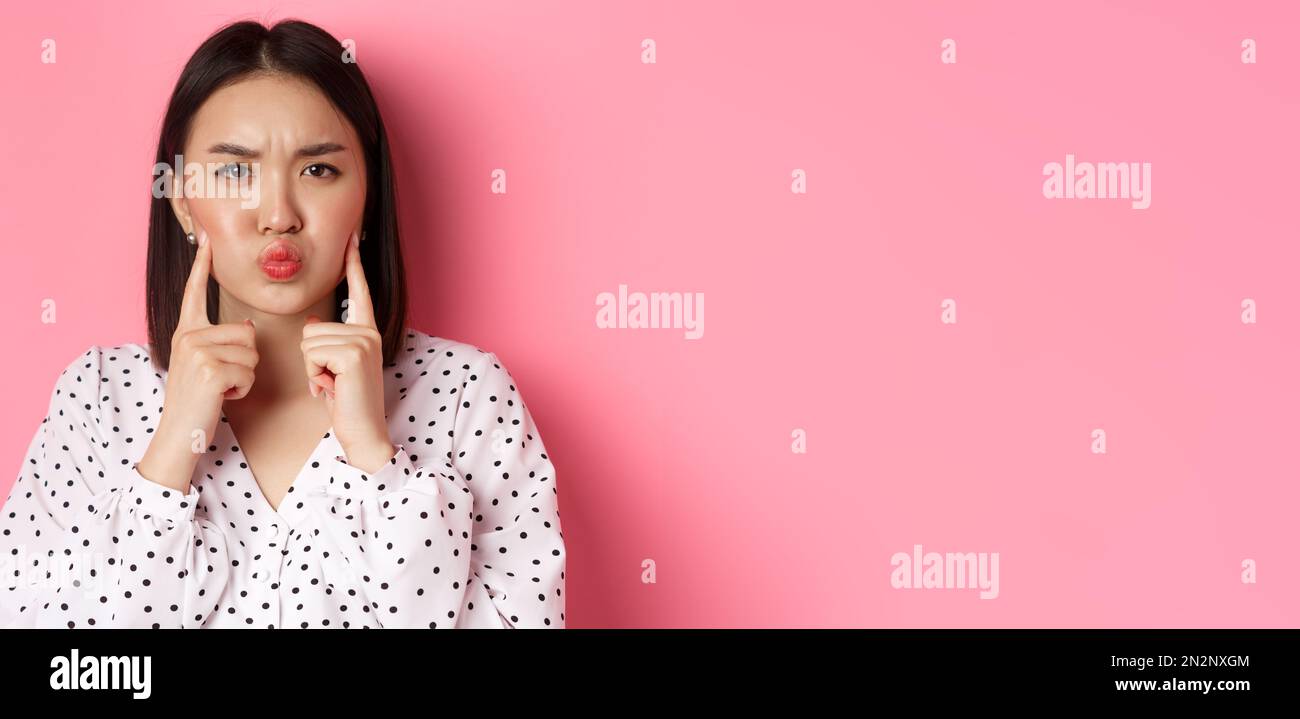 Beauty and lifestyle concept. Cute asian woman making grumpy face ...