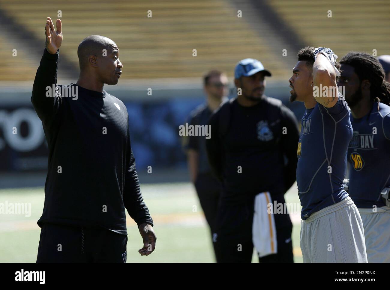 Oakland Raiders wide receivers coach Rob Moore, left, gives drill ...