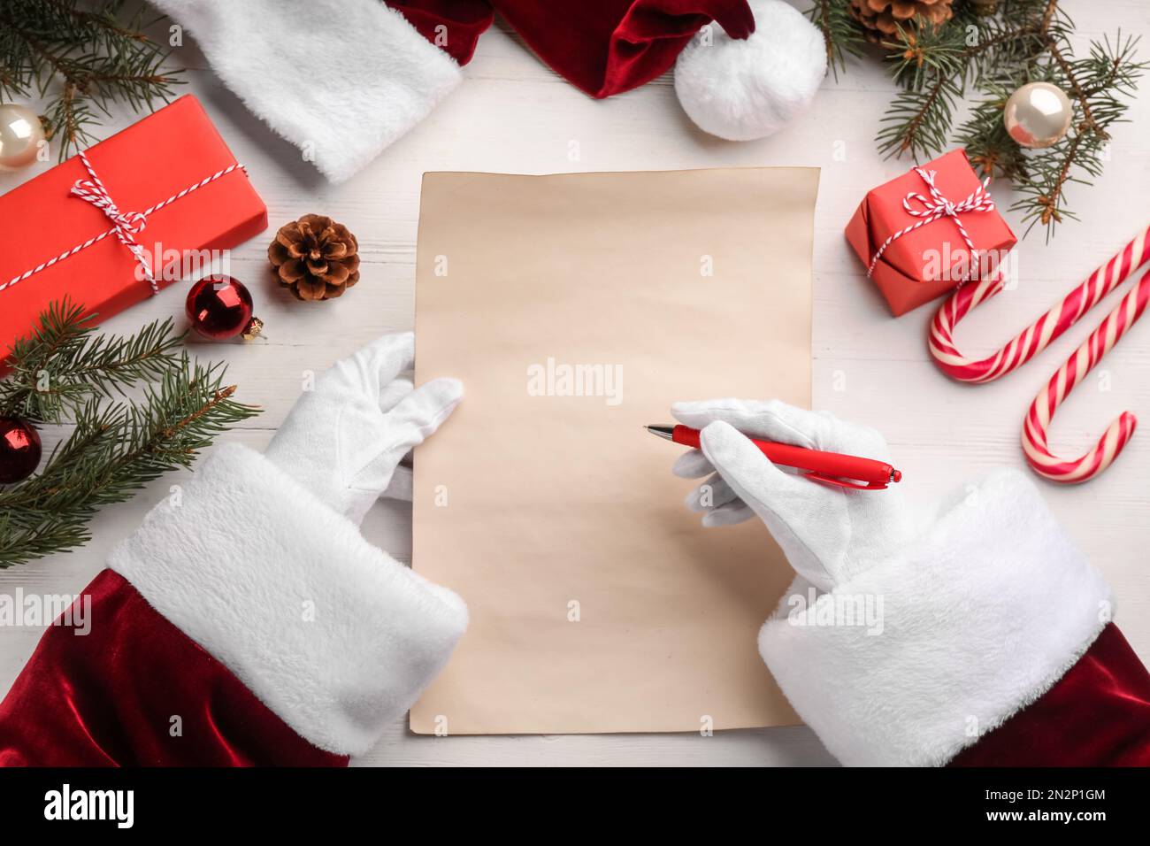 Santa Claus writing letter at white wooden table, top view. Christmas ...