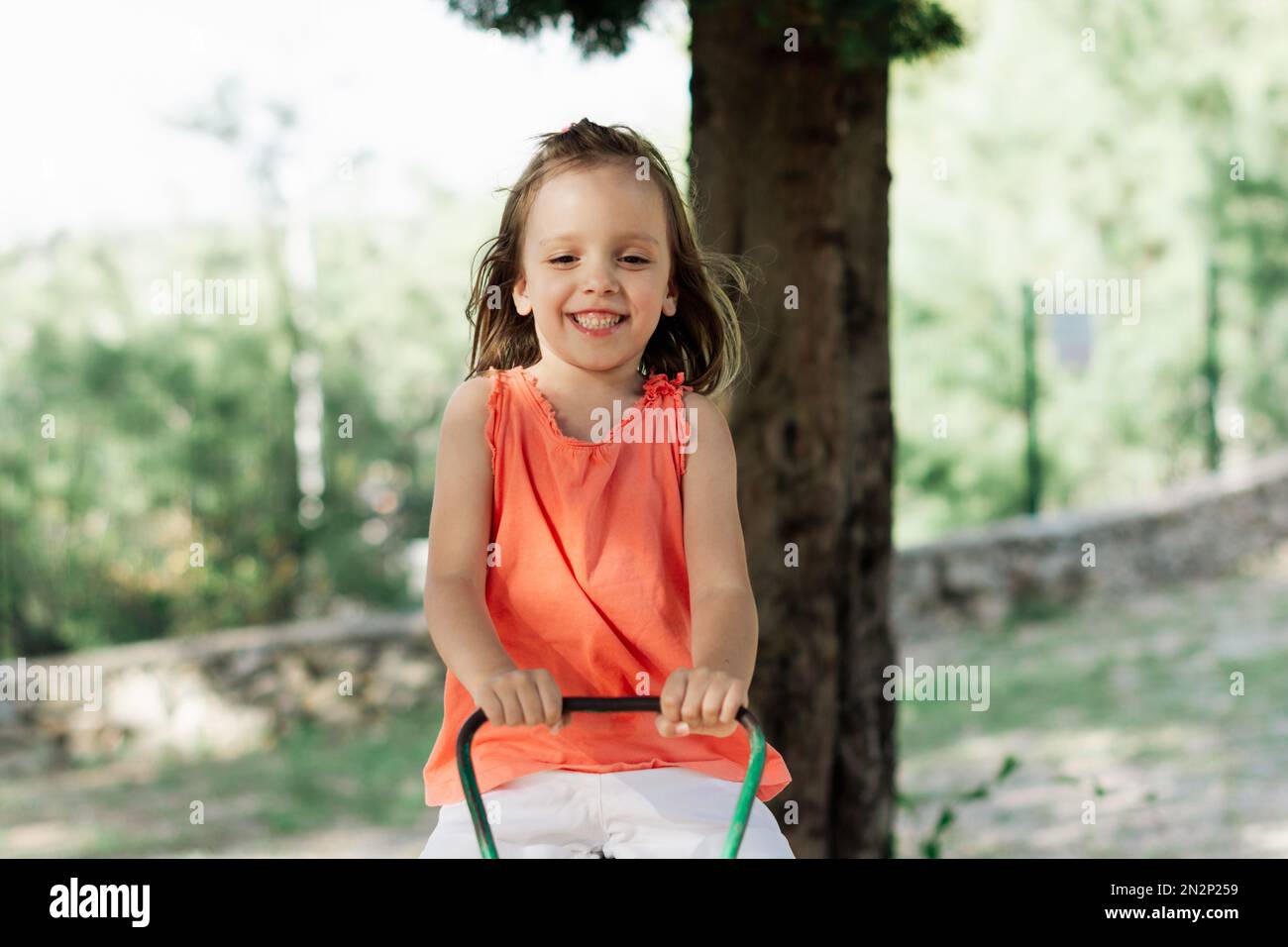 Cute girl playing at playground during summer day Stock Photo - Alamy