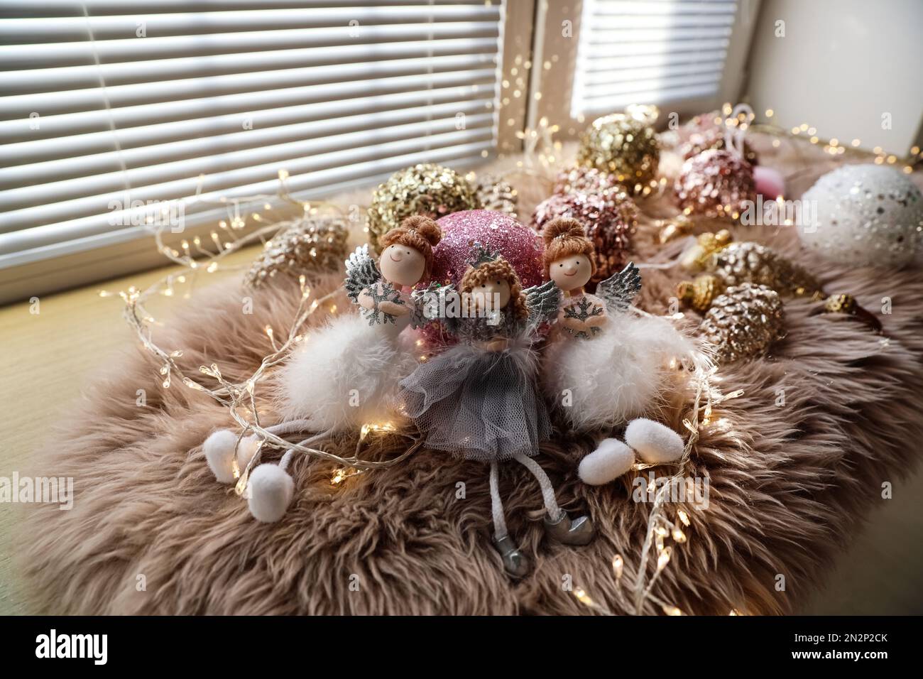 Beautiful angel dolls and shiny bauble on window sill indoors Stock ...