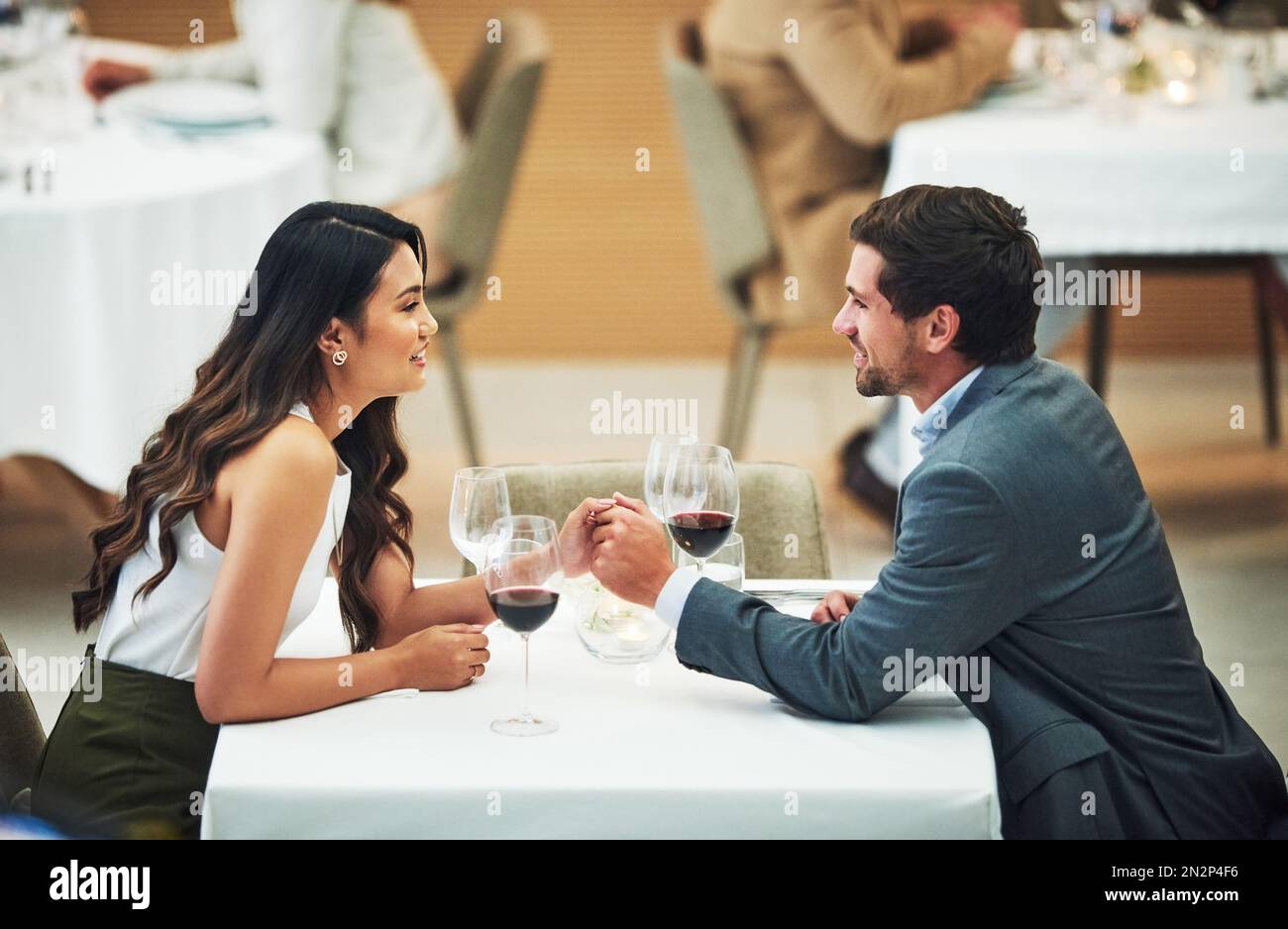 Restaurant, date and couple holding hands with wine for romantic dinner ...