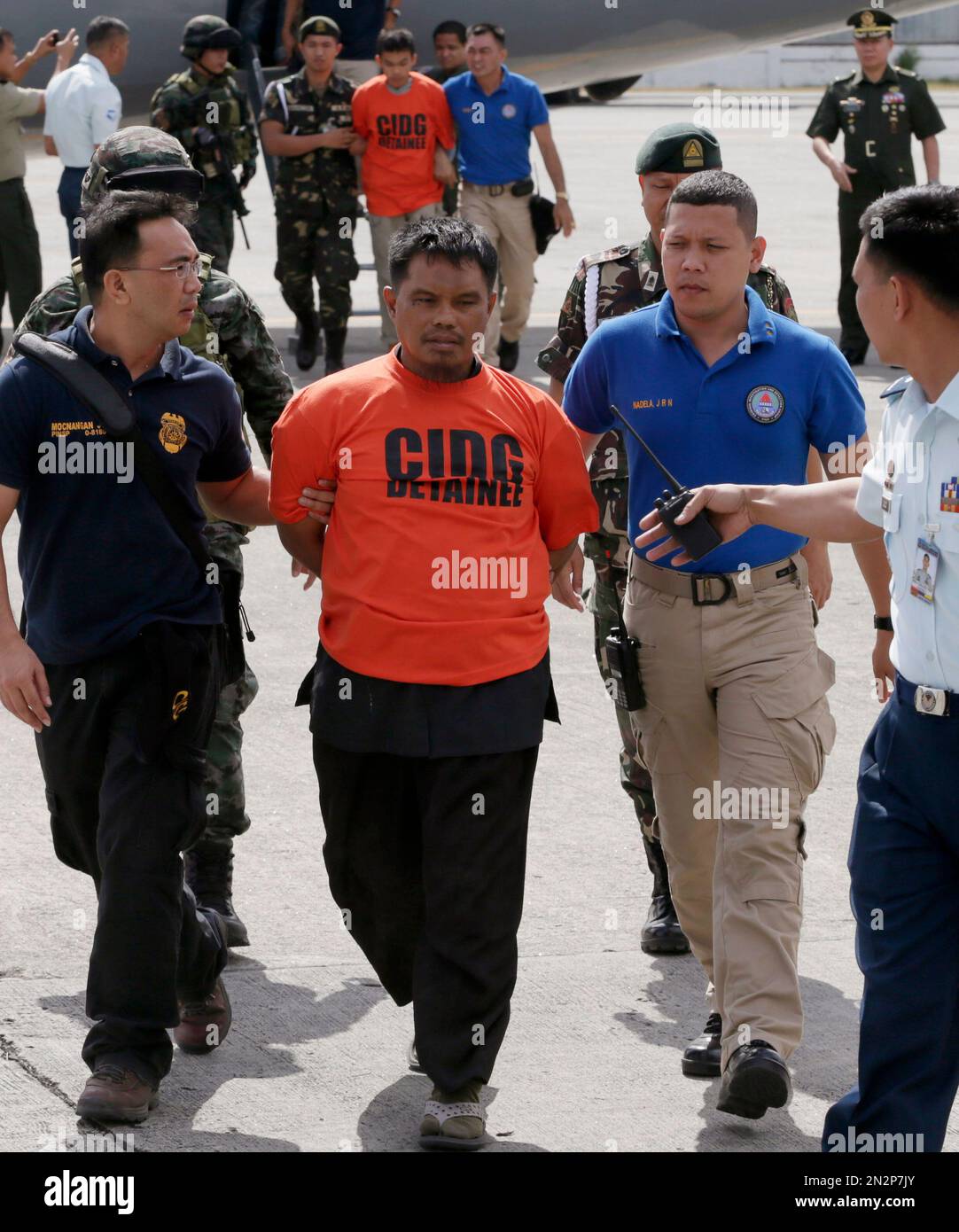 Army and police forces escort handcuffed Mohammad Ali Tambako, the ...